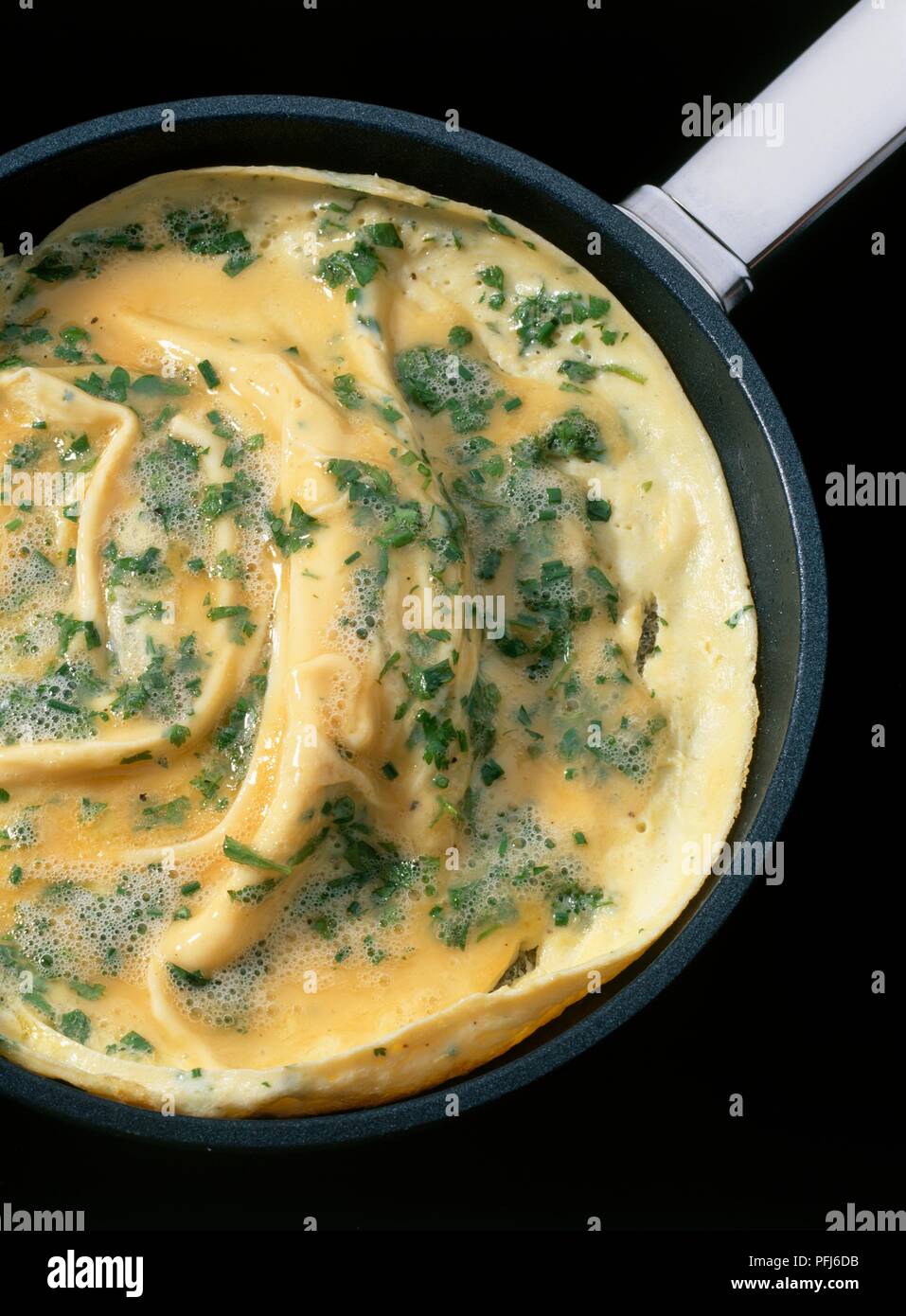 French omelette cooking in frying pan Stock Photo - Alamy
