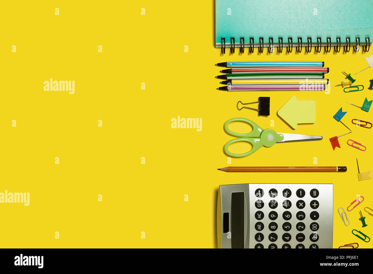 multiple school and office suplies and gadgets lying diagonally on a ...