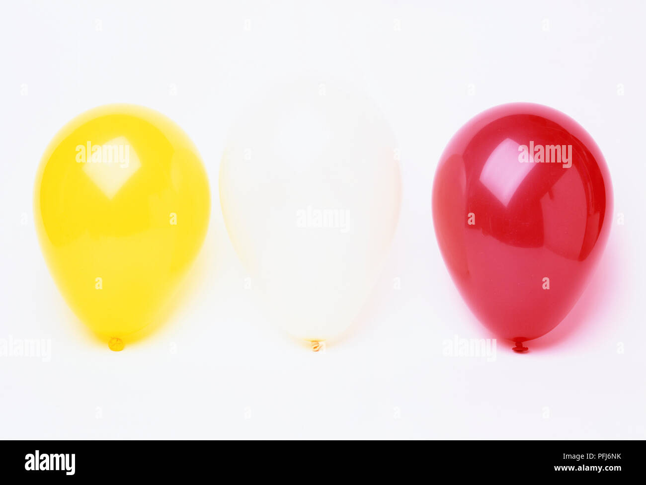 Three inflated balloons, yellow, white and red Stock Photo - Alamy