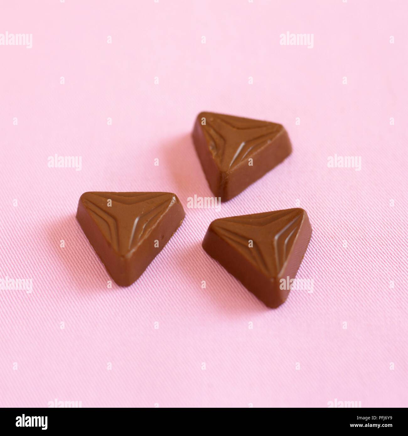 Three triangular shaped chocolates Stock Photo - Alamy