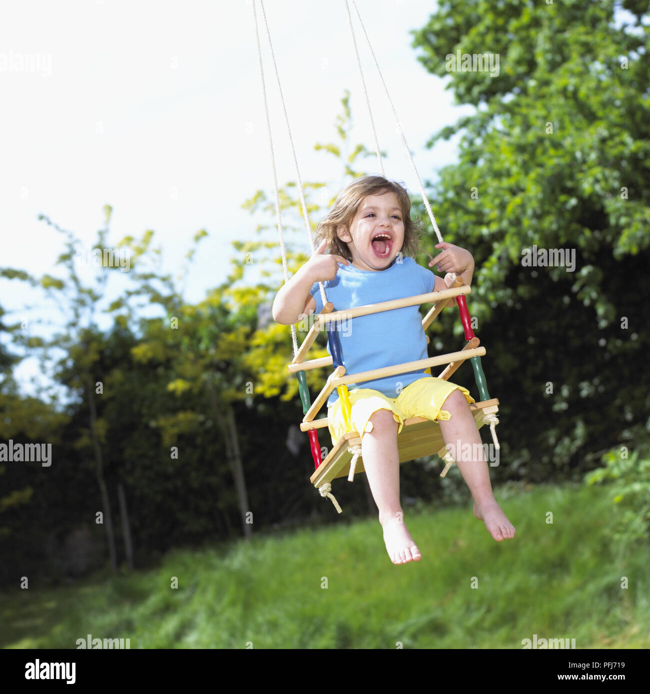Girl on a swing, mouth wide open Stock Photo - Alamy