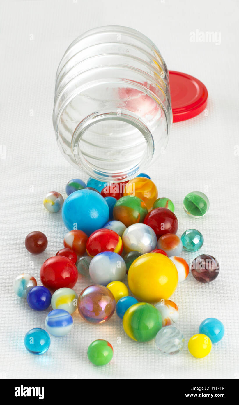 Rubber balls spilled out of a glass jar Stock Photo - Alamy