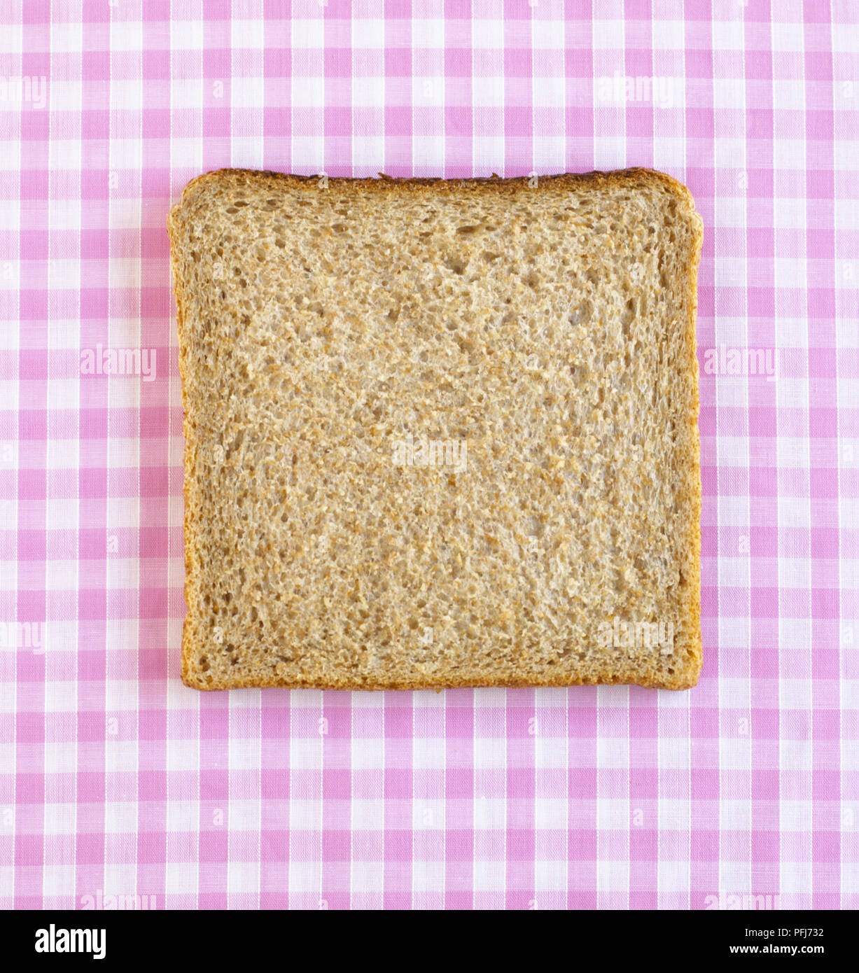 Slice of brown bread, checkered background Stock Photo - Alamy