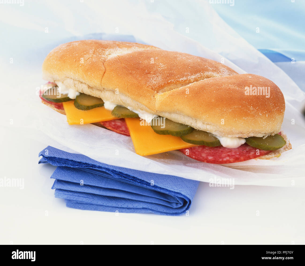 Soft white bread baguette, filled with slices of salami, cheese and ...