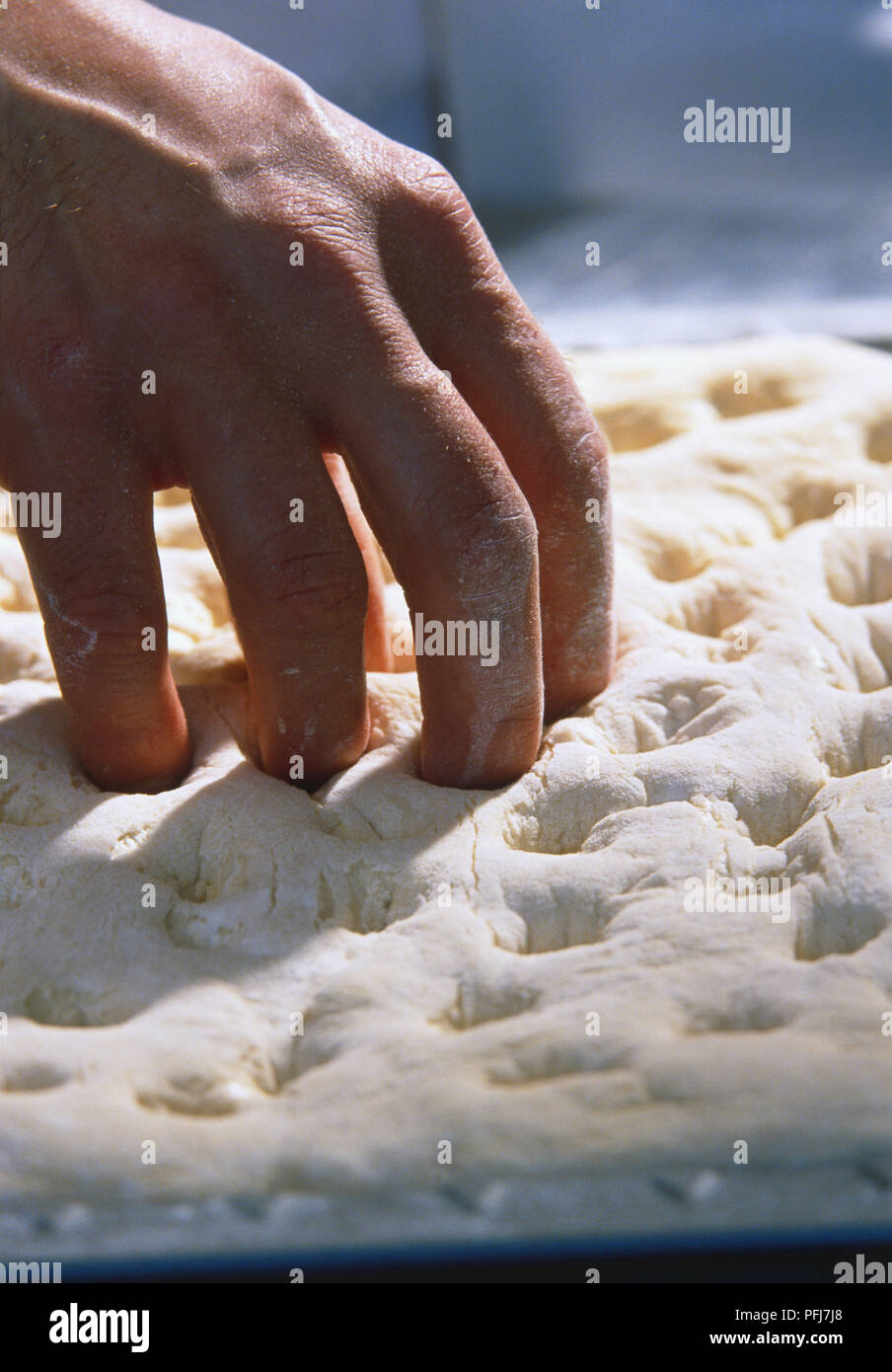 Fingers pressing holes into thick layer of fresh dough Stock Photo - Alamy