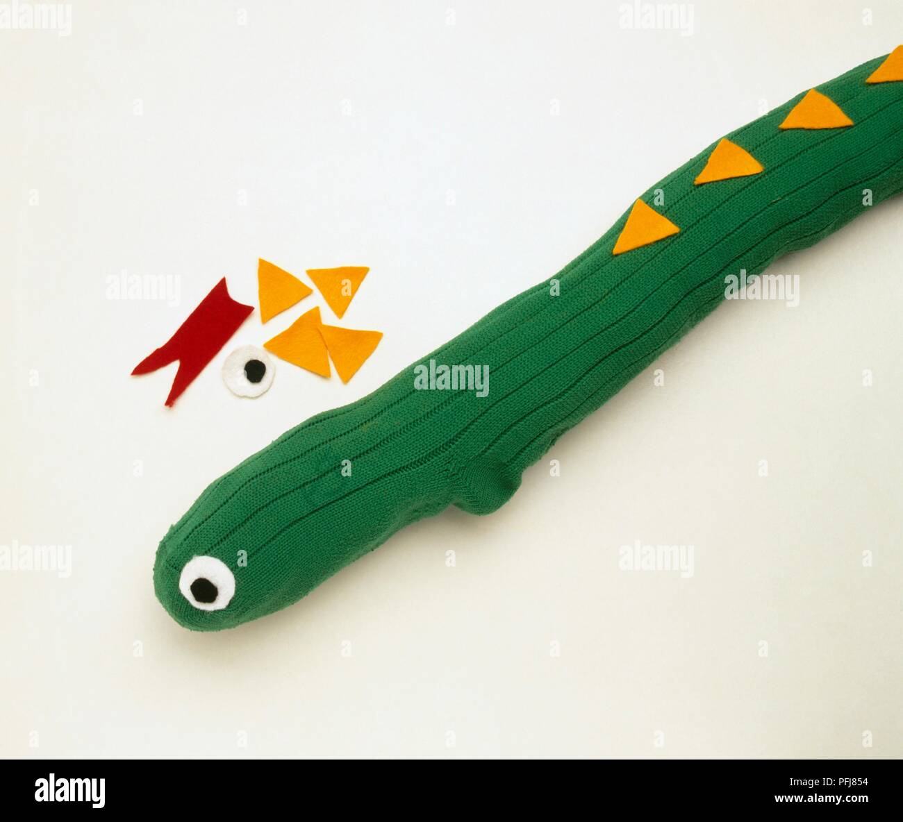 Stuffed green stocking with cut out shape of eye at toe, red and yellow ...