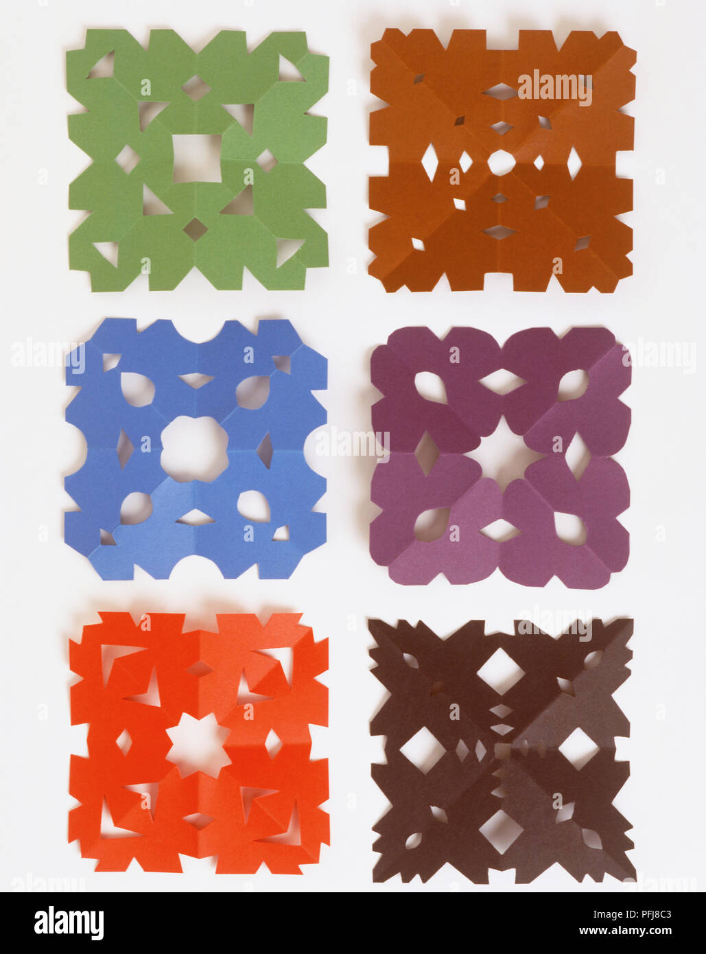 Six colourful paper squares with different patterns cut into them ...