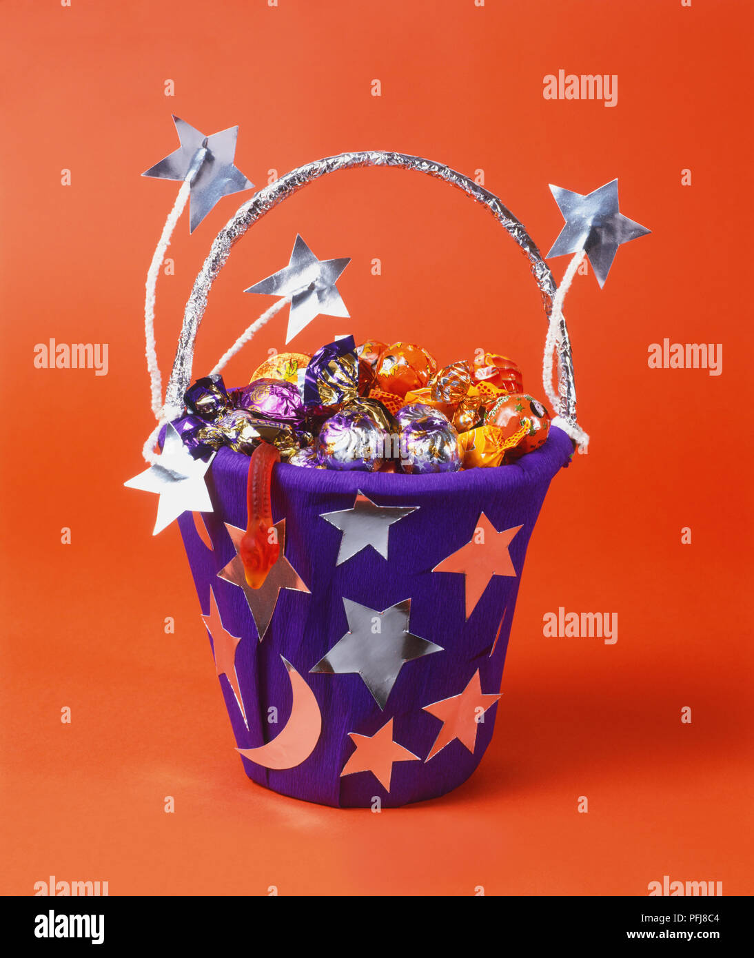 Purple bucket decorated with silver paper stars and filled with wrapped ...
