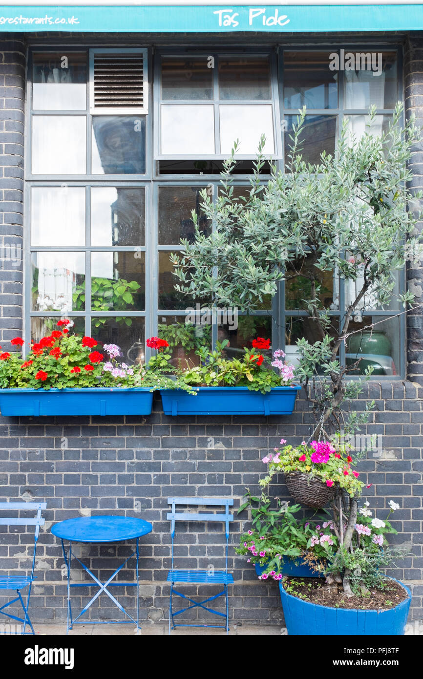 Bright blue tables and chairs outside Tas Pide Turkish mezze restaurant ...