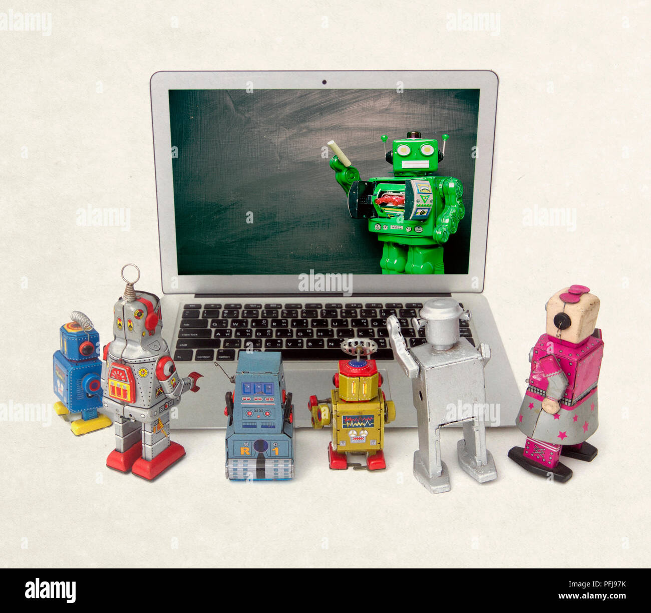 Machine learning concept with retro robots at a laptop computer ...
