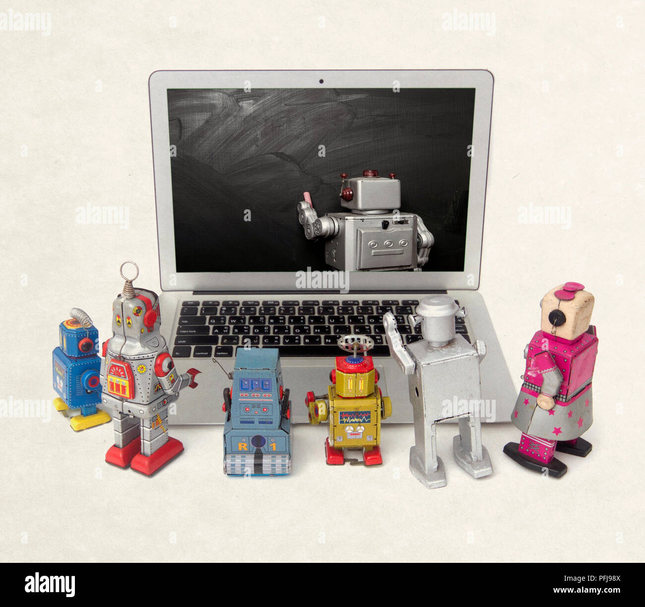 Machine learning concept with retro robots at a laptop computer ...