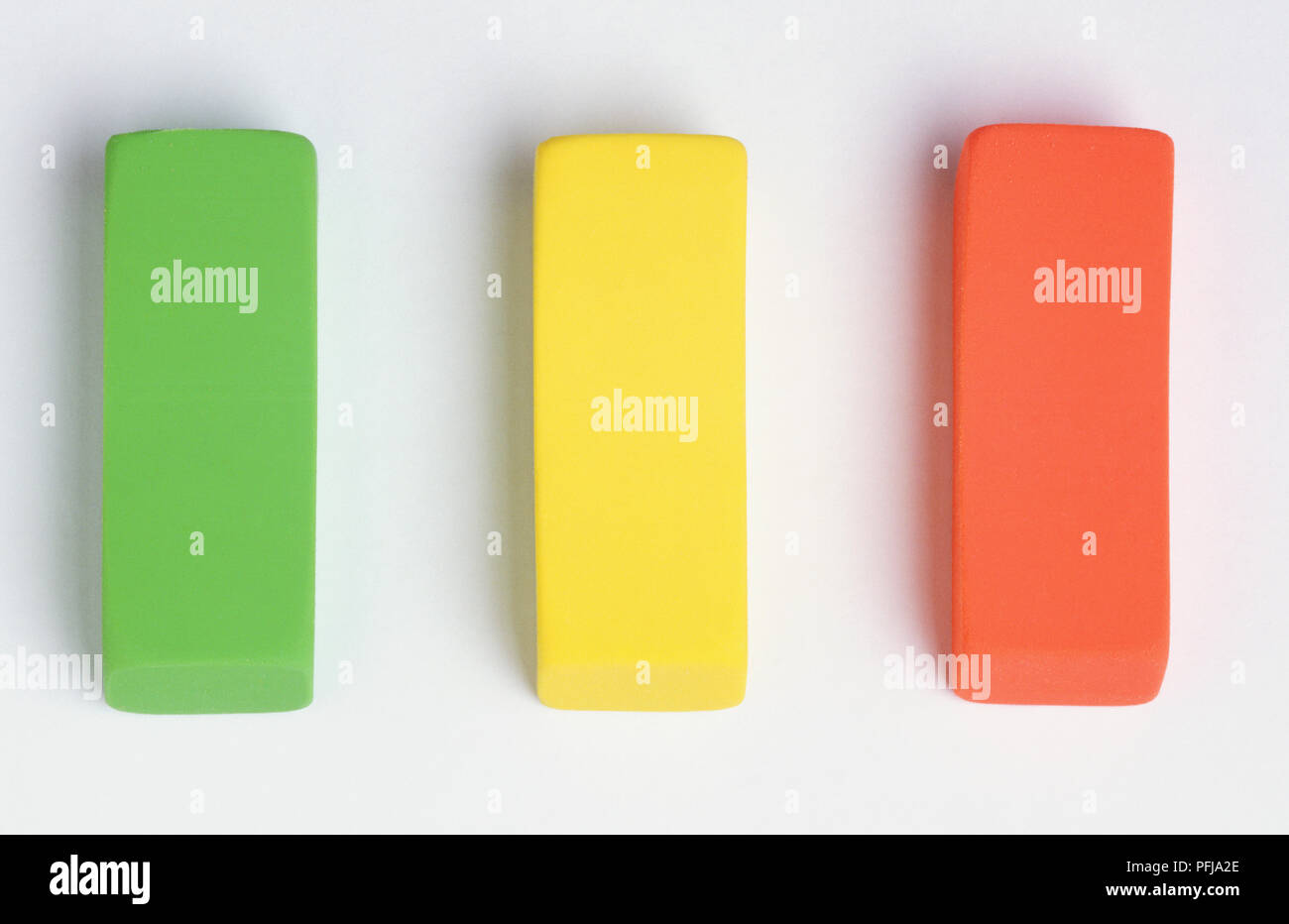 Three erasers, red, yellow and green Stock Photo - Alamy