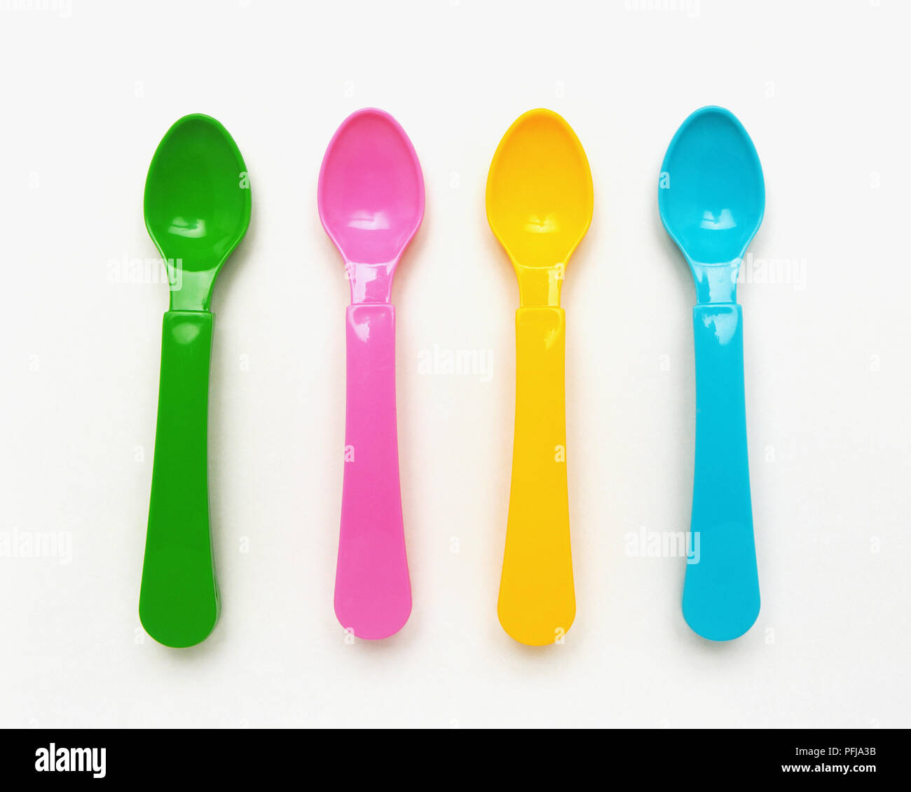 Four plastic spoons, blue, yellow, pink and green Stock Photo - Alamy