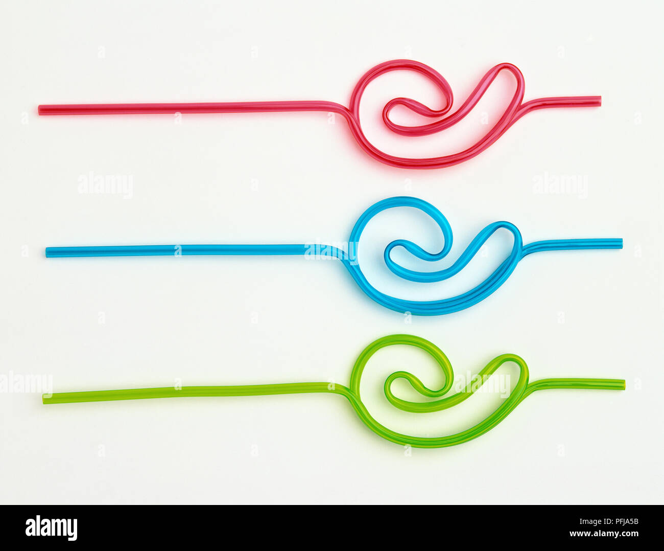 Three drinking straws, red, blue and green, twisted in middle Stock ...