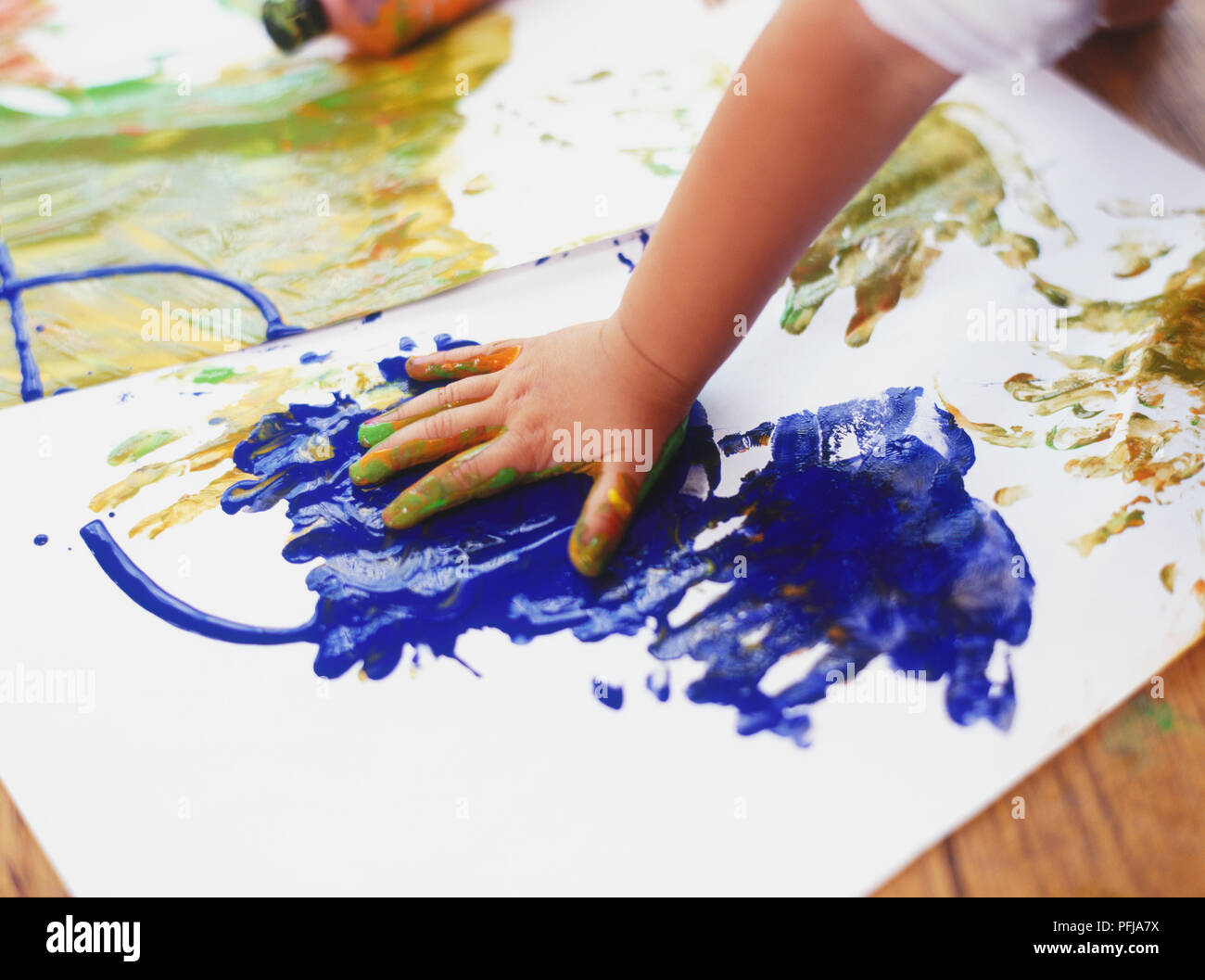 Child's hand on surface covered in blue paint Stock Photo - Alamy