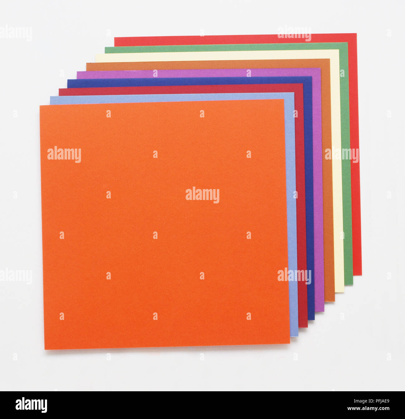 Square pieces of coloured paper, one behind other Stock Photo - Alamy