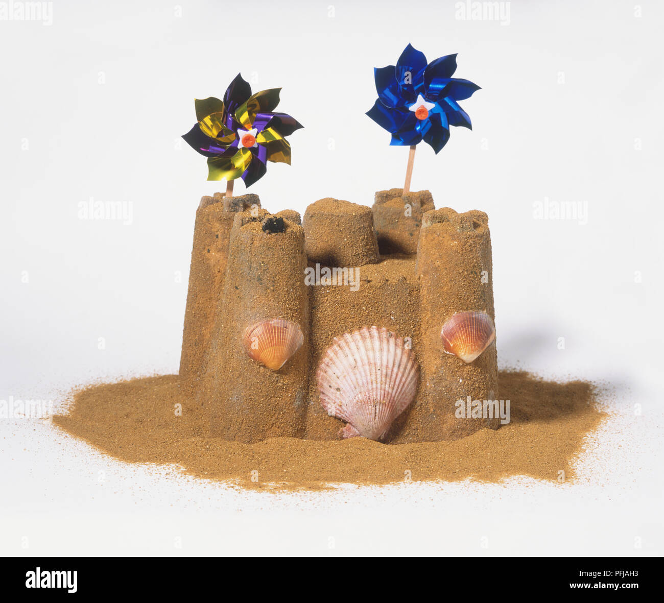 Sandcastle with shells and toy windmills Stock Photo - Alamy