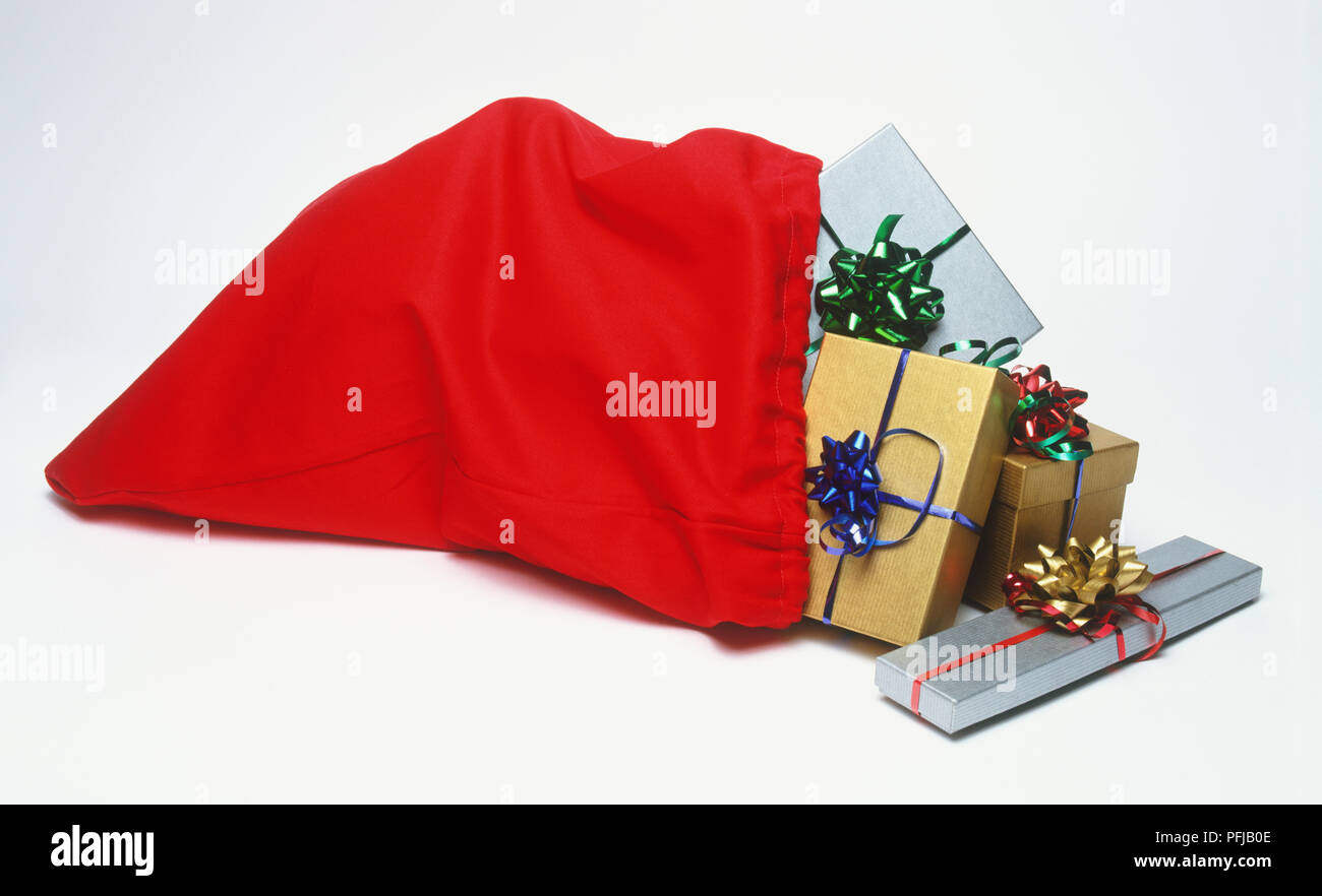 Wrapped presents spilling out of red bag Stock Photo - Alamy