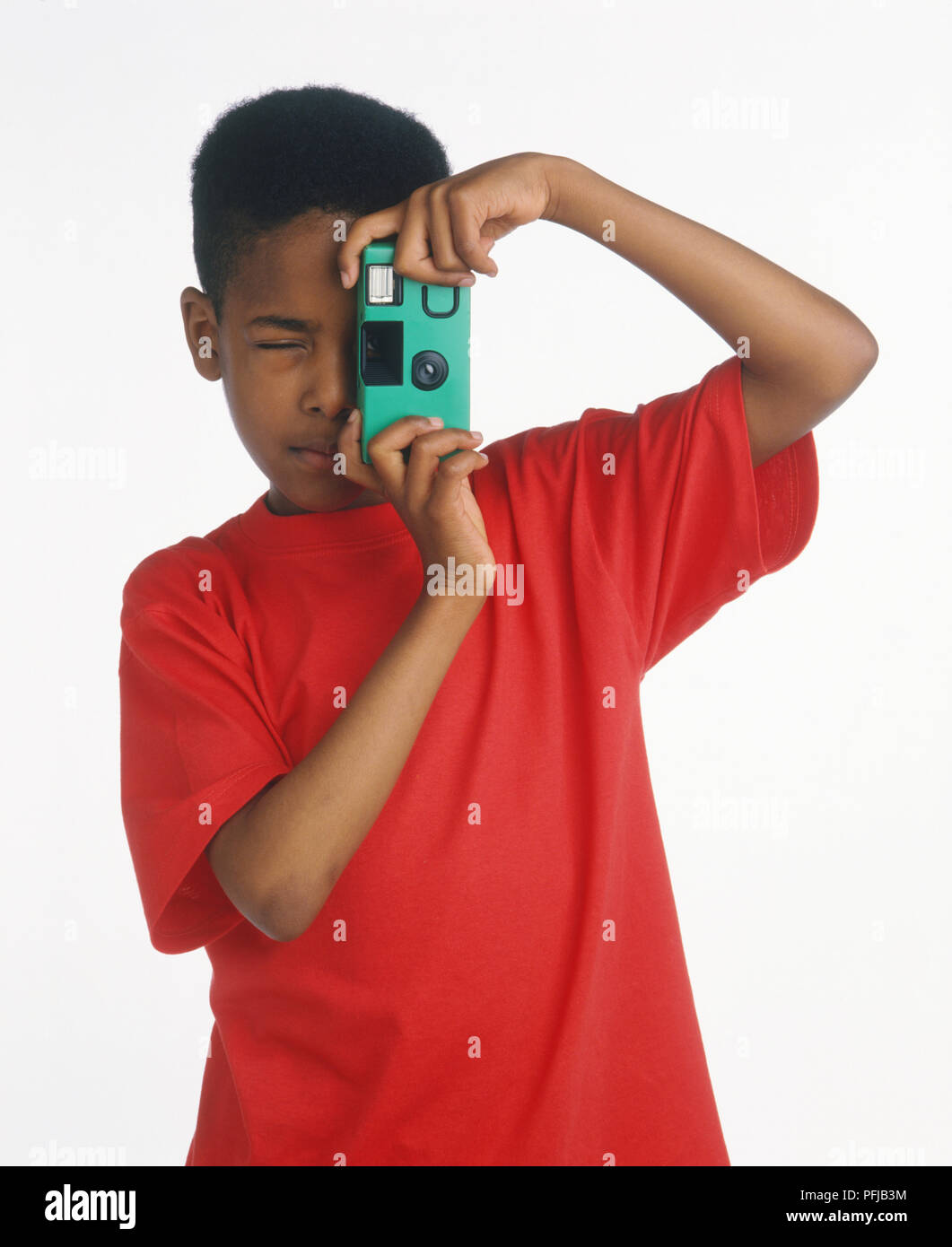 Standing boy taking photograph with film camera, front view Stock Photo ...