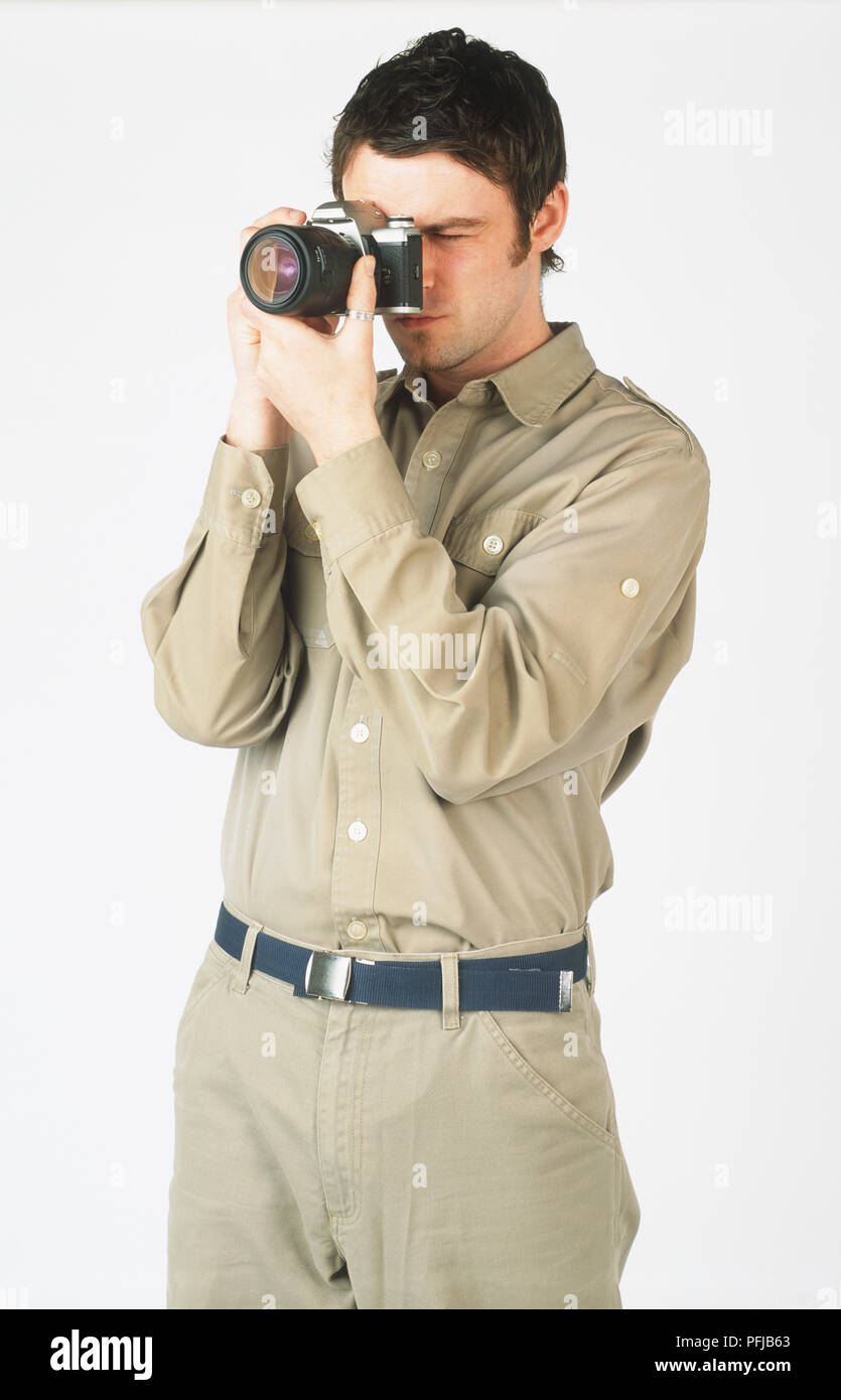 Photographer in khaki clothing holding a camera Stock Photo - Alamy