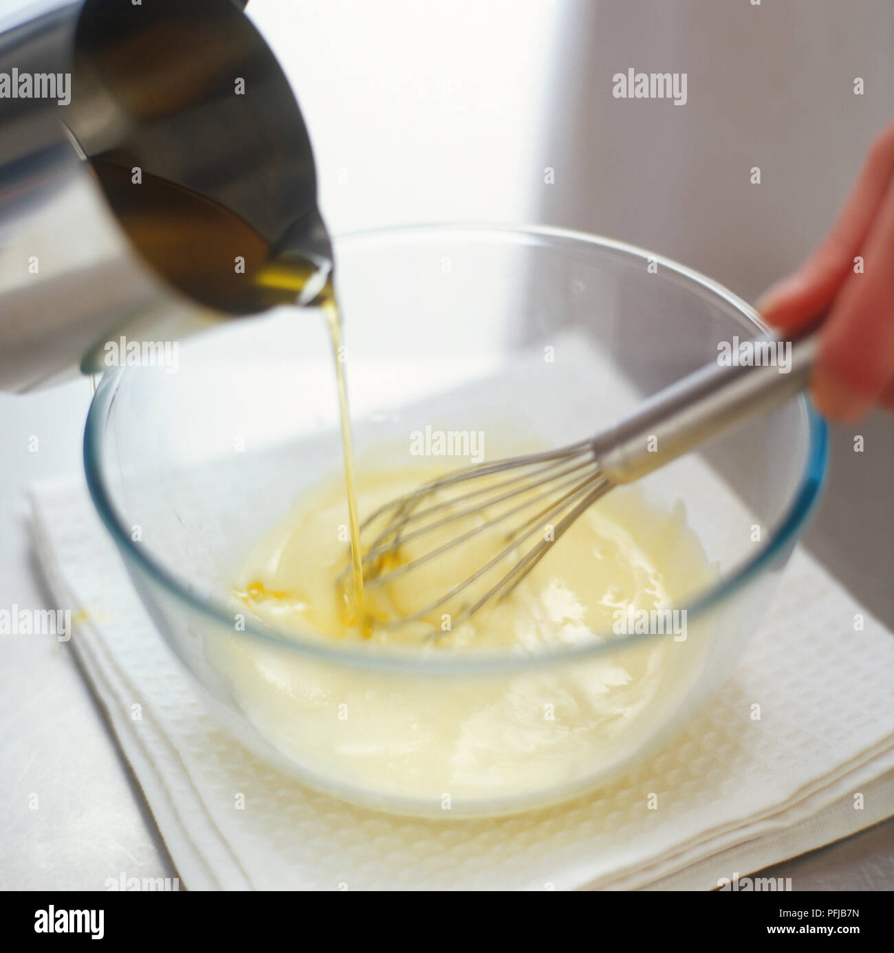 Making Hollandaise sauce, pouring clarified butter into bowl while ...