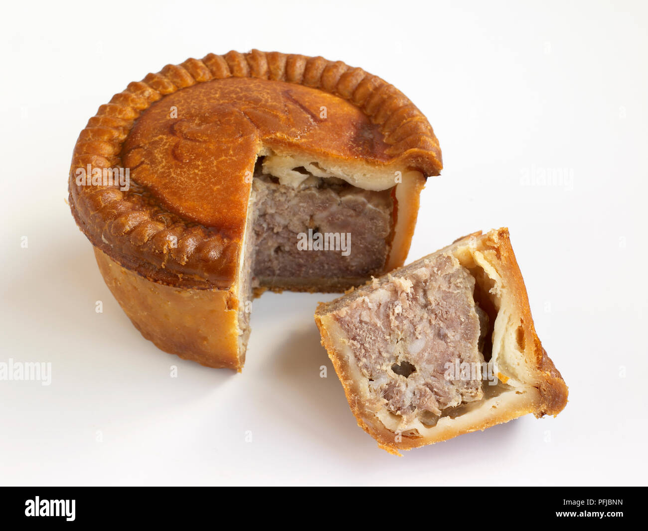Pork pie with pastry crust, and slice showing meat inside, close-up ...