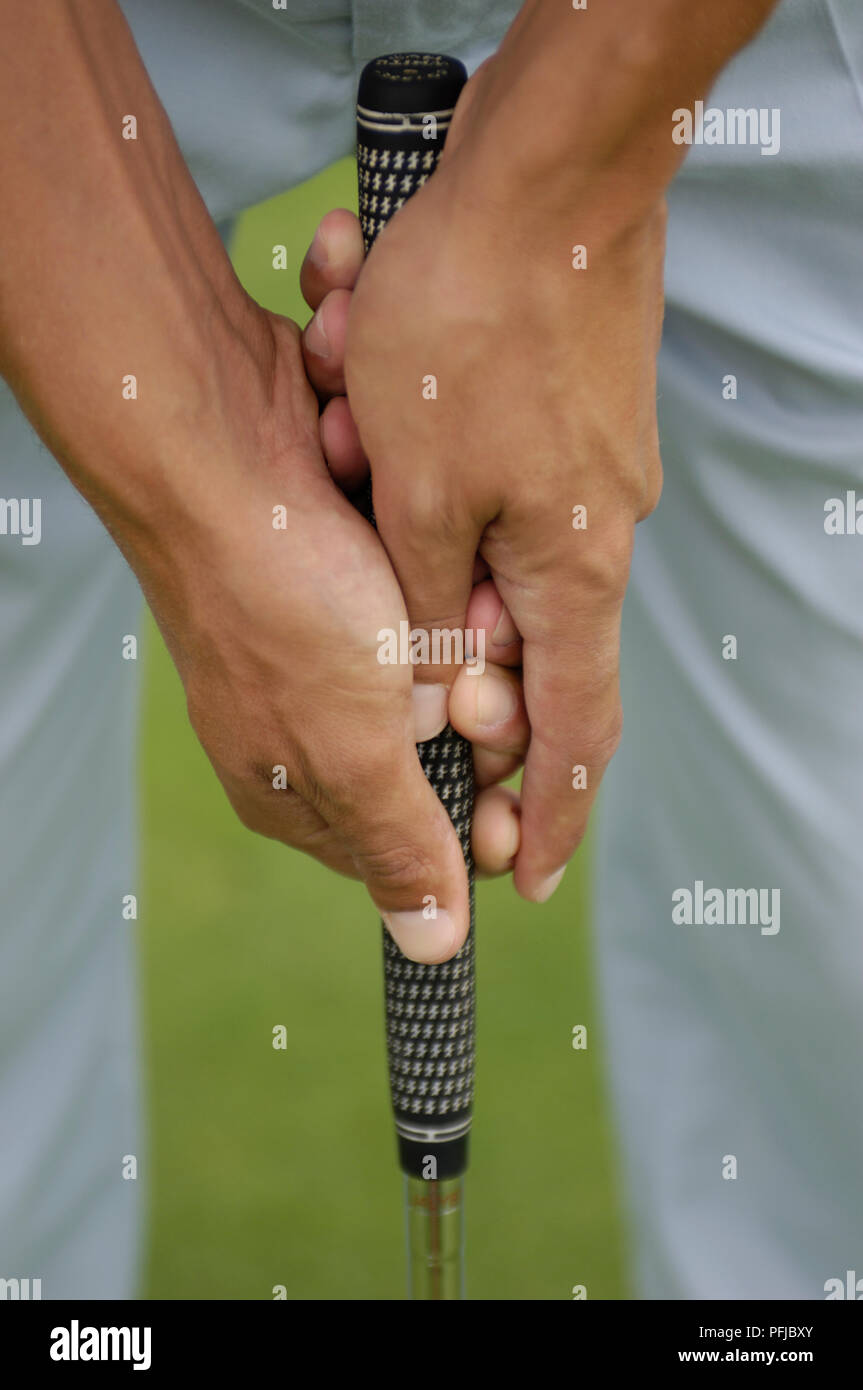 Hands gripping handle of golf club, close-up Stock Photo - Alamy