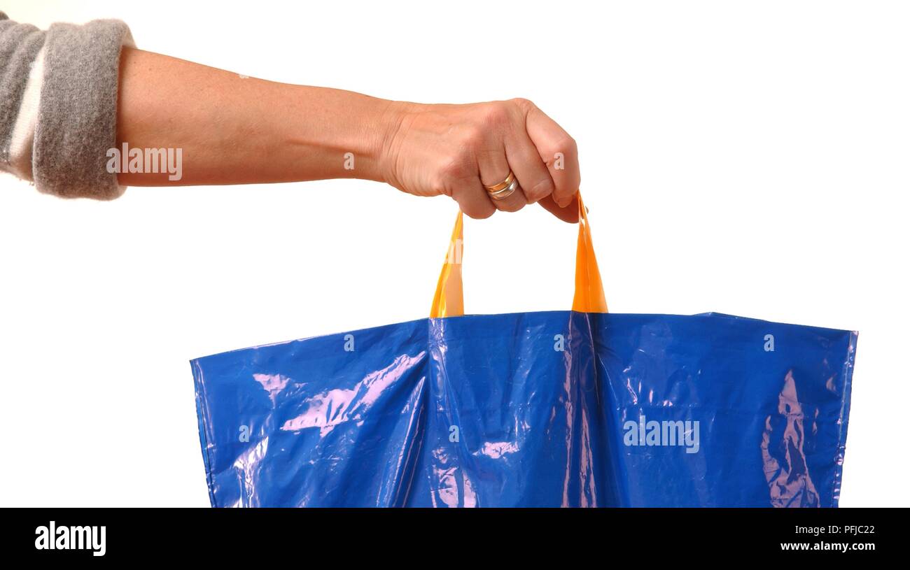 Woman's hand holding plastic shopping bag, close-up Stock Photo - Alamy