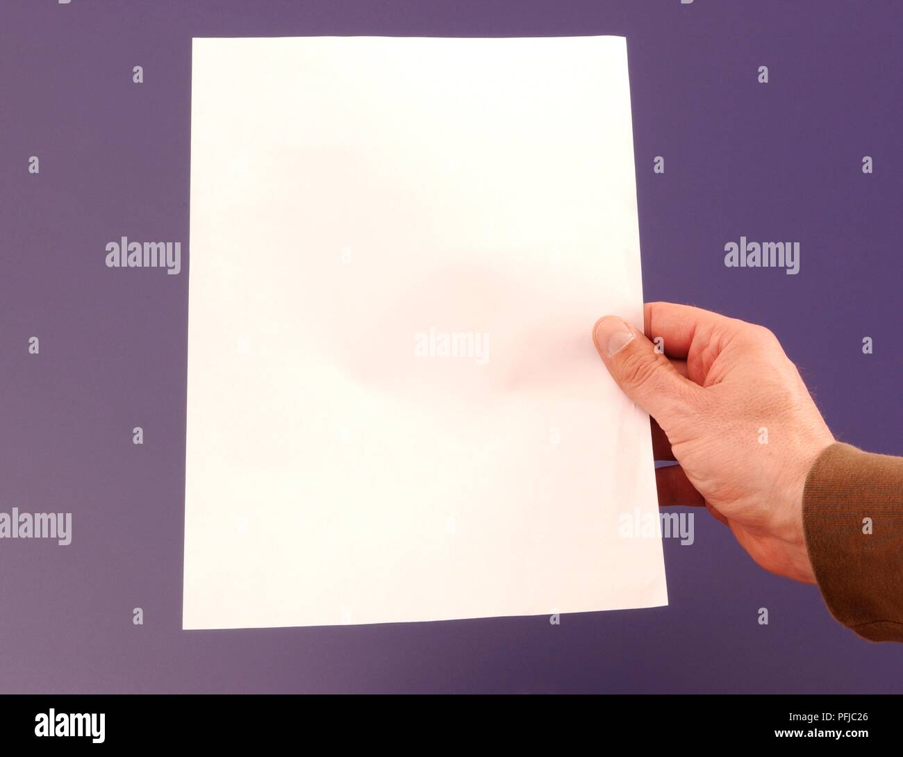 Man's hand holding blank sheet of paper Stock Photo - Alamy