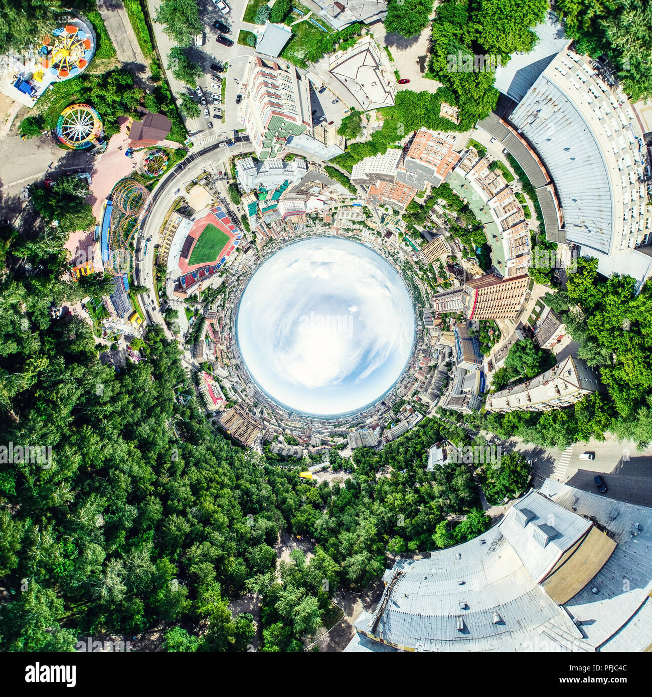 Aerial city view with crossroads and roads, houses, buildings, parks and parking lots. Sunny ...