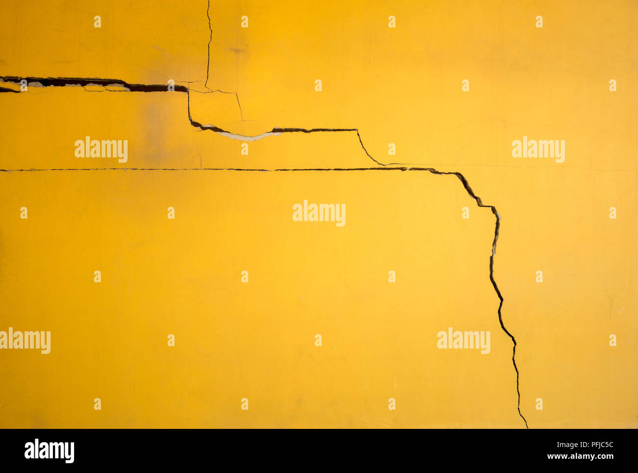 Broken yellow color concrete wall with cracked Stock Photo - Alamy