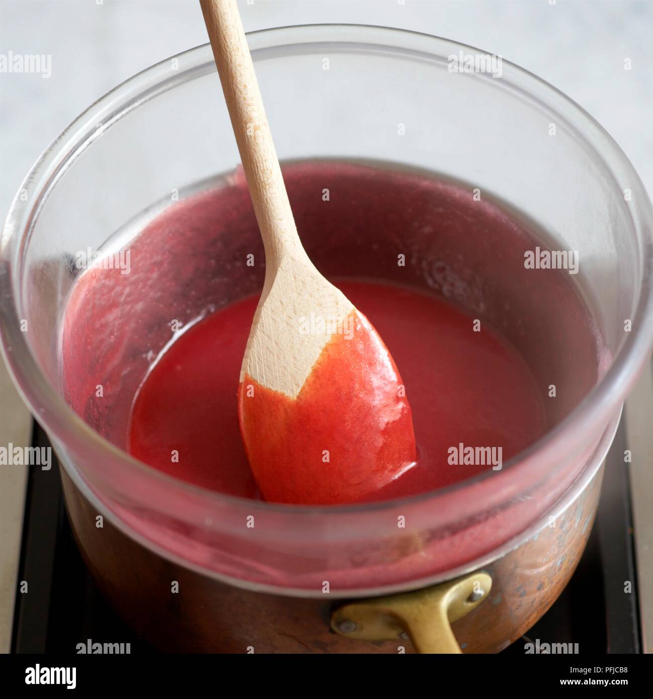 Wooden spoon and raspberry curd in glass bowl on saucepan Stock Photo ...