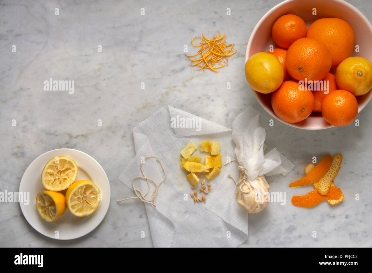 Oranges in bowl, lemon halves on plate, peel, dried fruit and pips on ...