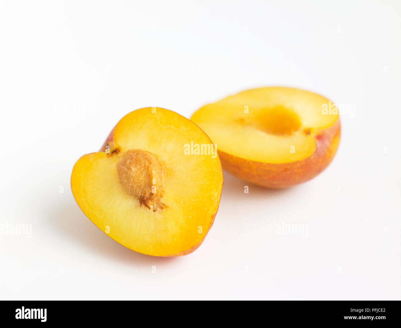 Yellow plum cut in two, close-up Stock Photo - Alamy