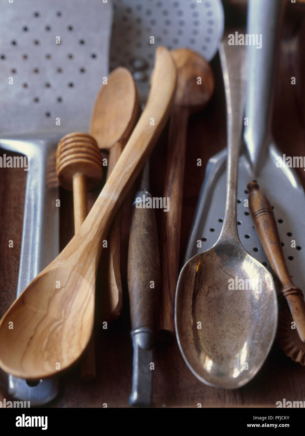 Collection of wooden and metal spoons, honey dipper and slotted spoons ...