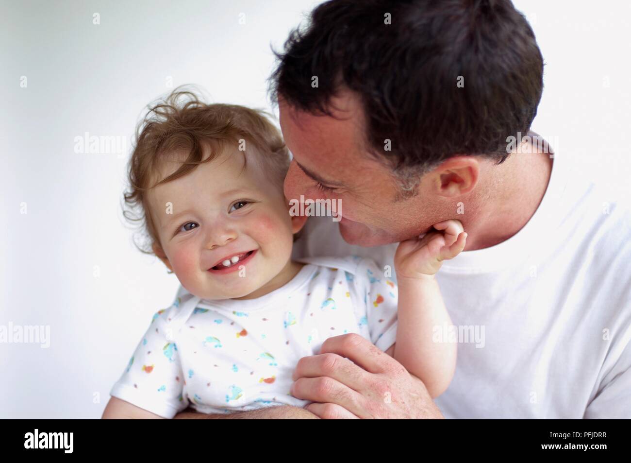Man holding smiling baby boy in arms, close-up Stock Photo - Alamy