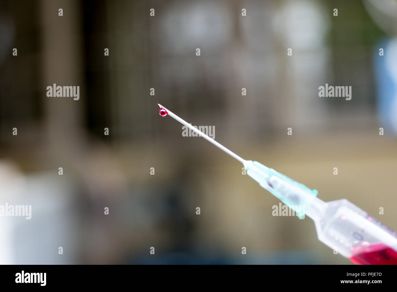Conceptual syringe with blood in blur background Stock Photo - Alamy