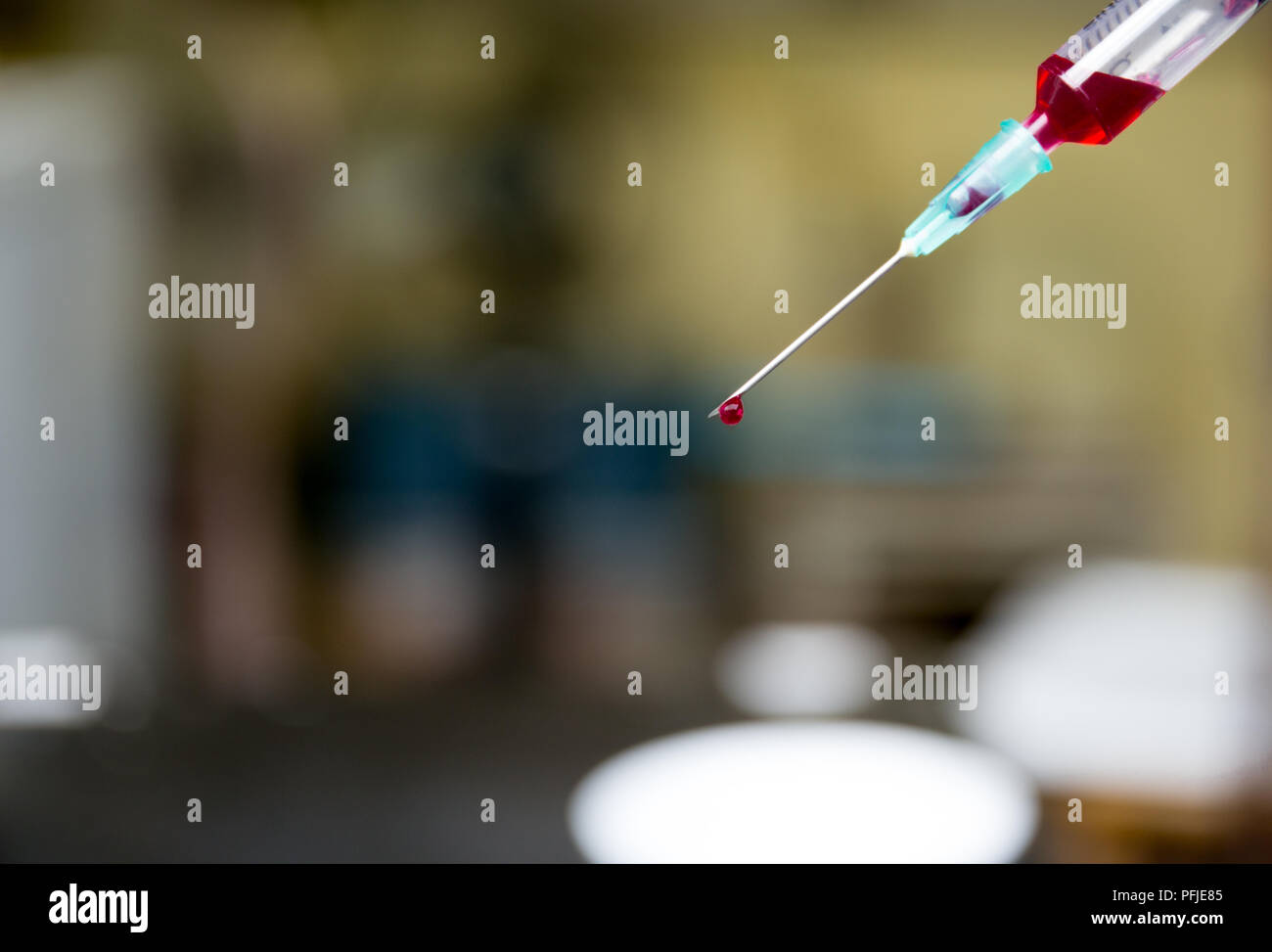 Conceptual syringe with blood in blur background Stock Photo - Alamy
