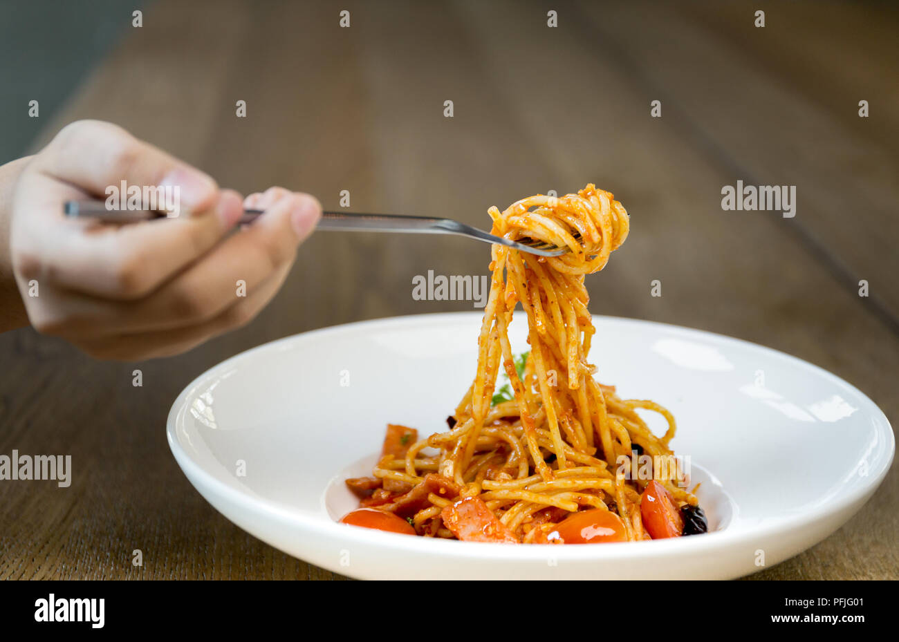 Italian food hand holding fork with spaghetti bolognese in white plate ...