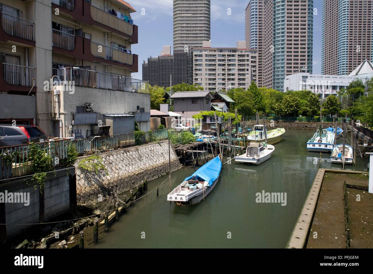 Japan, Tokyo, Koto-ku, boat moored in canal with skyscrapers in the ...