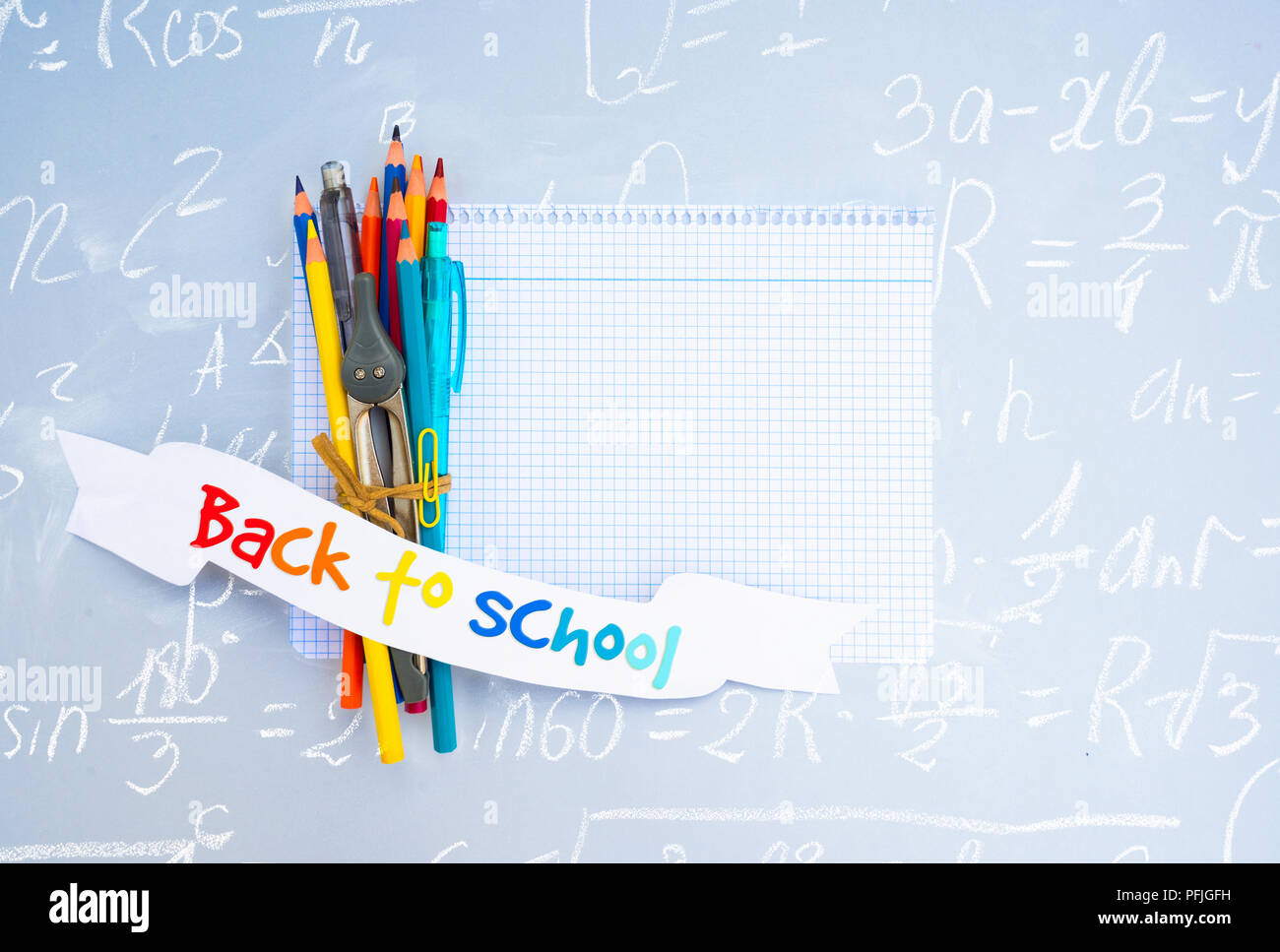 Back to school concept on blue - office supplies on ruled paper on blue ...