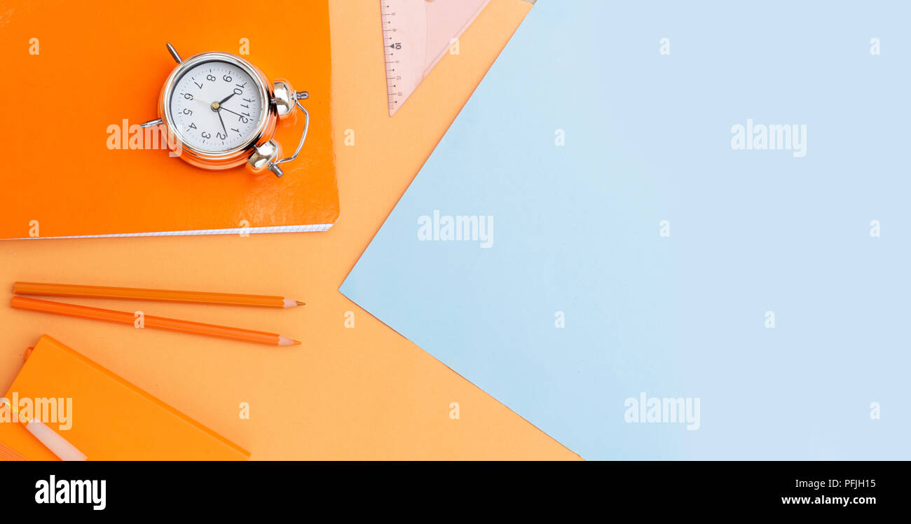 Back to school styled scene with school supplies on blue and orange ...