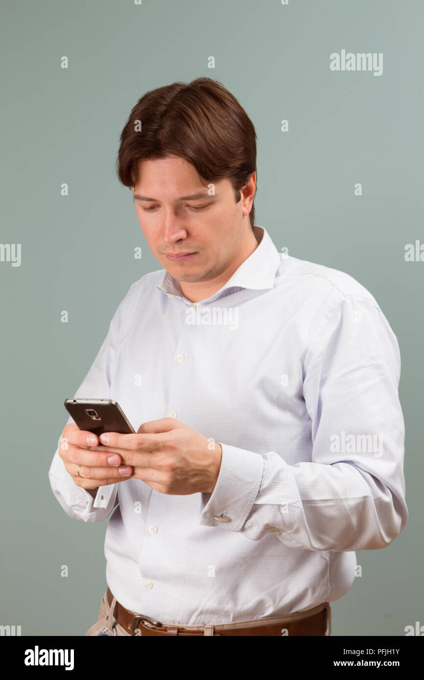 Typing message. Handsome young man with afro hair in shirt holding ...