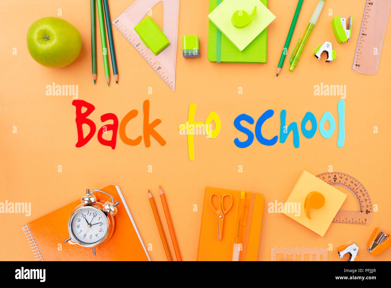 Back to school styled scene withorange and green school supplies on ...