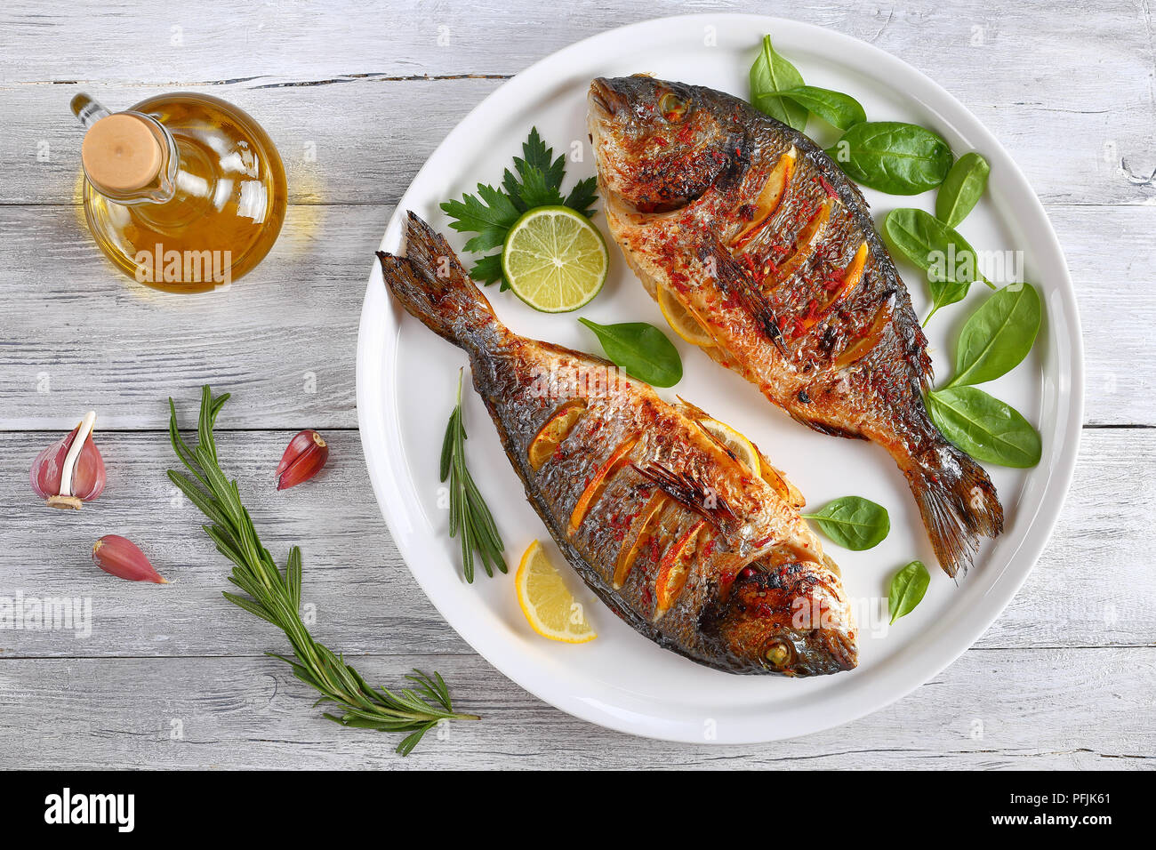 roasted dorado or sea bream fish with lemon and orange slices, spices ...
