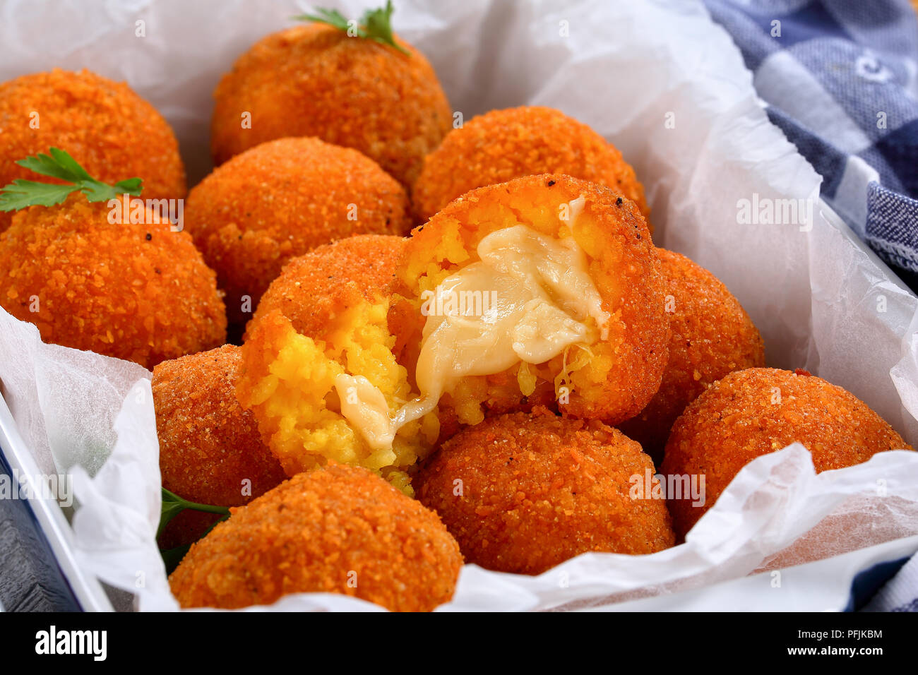 italian arancini - saffron rice balls stuffed with cheese in baking ...