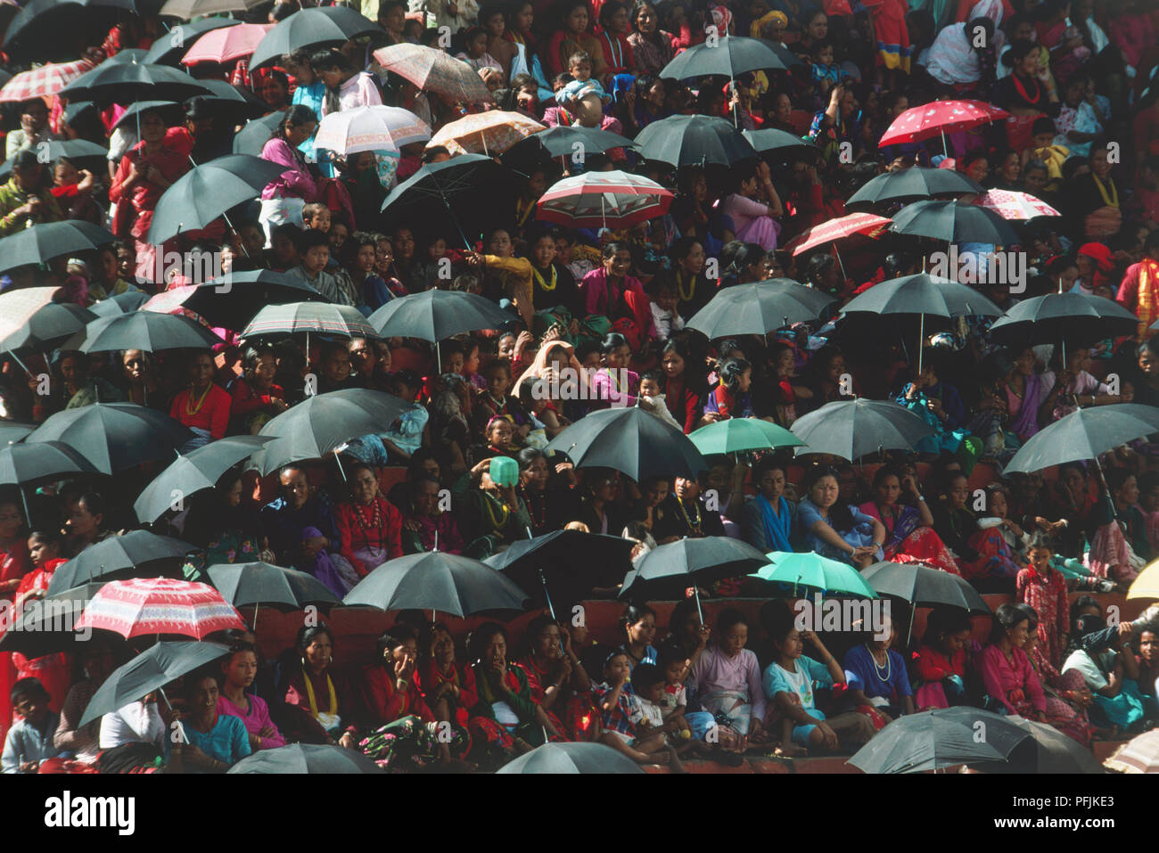 Crowd sitting holding umbrella hi-res stock photography and images - Alamy