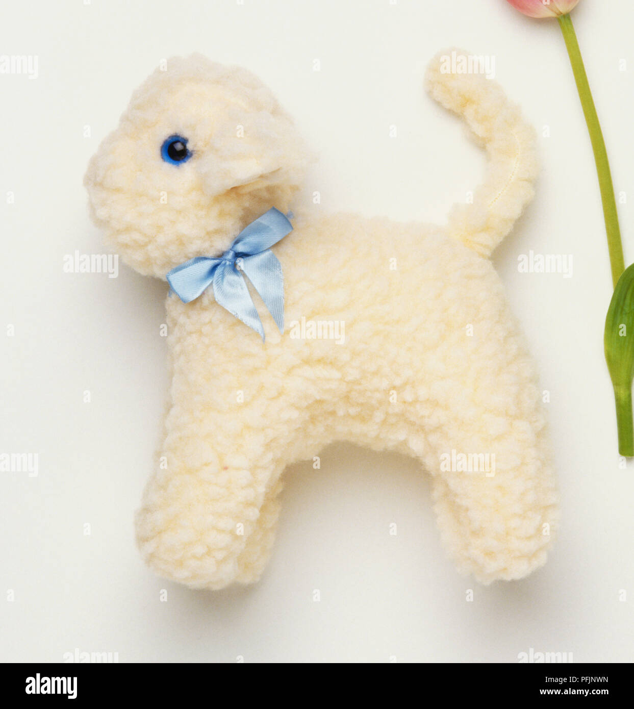 Toy lamb with blue bow around the neck, side view Stock Photo - Alamy