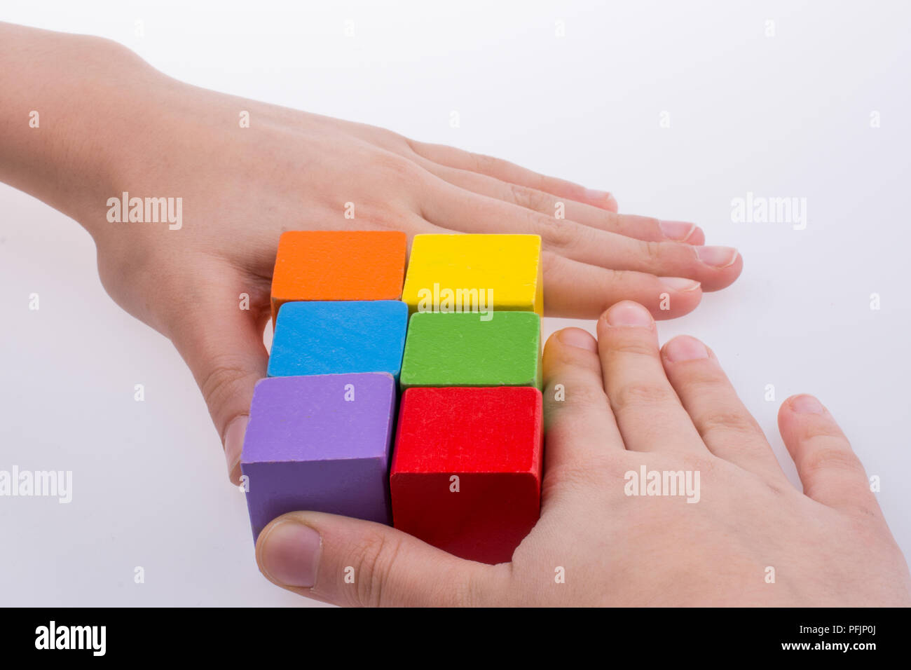 Hand playing with colorful cubes on a white background Stock Photo - Alamy