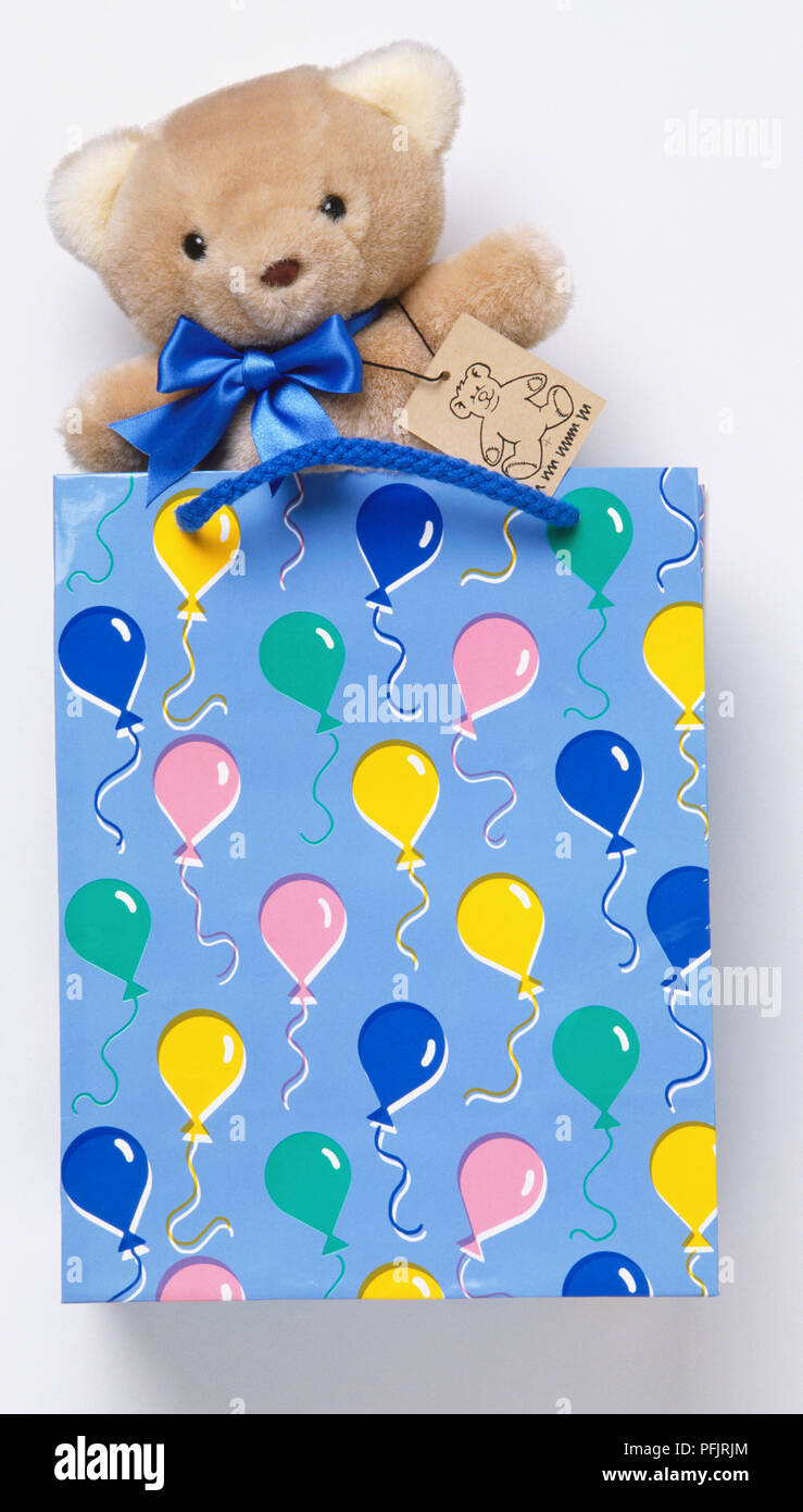 Teddy bear sticking out from top of a bag decorated with balloons Stock ...